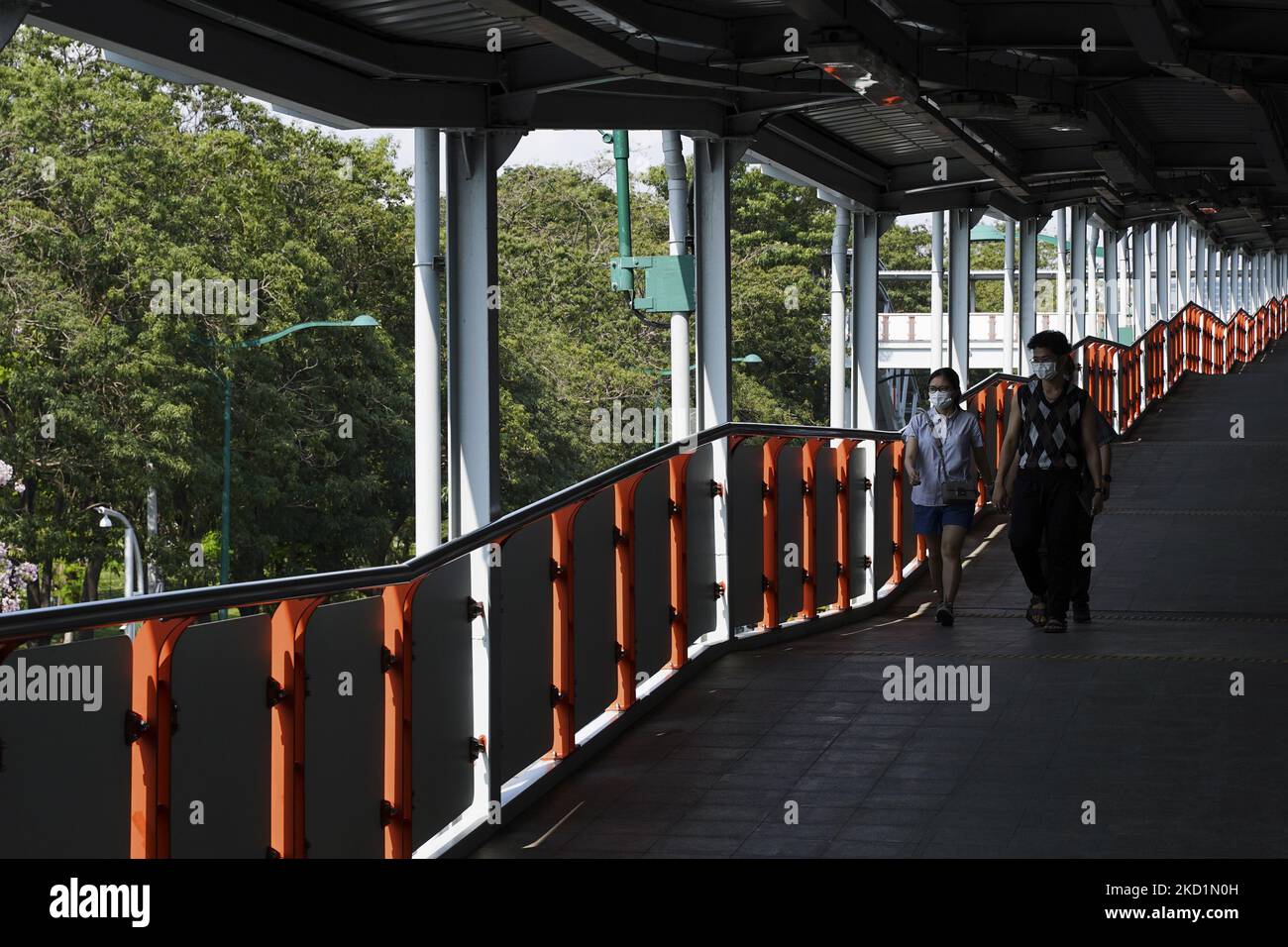 People walk across a deserted overhead walkway as they head to a ...