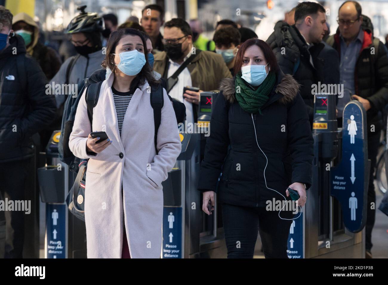 LONDON, UNITED KINGDOM - FEBRUARY 02, 2022: Commuters, some continuing ...