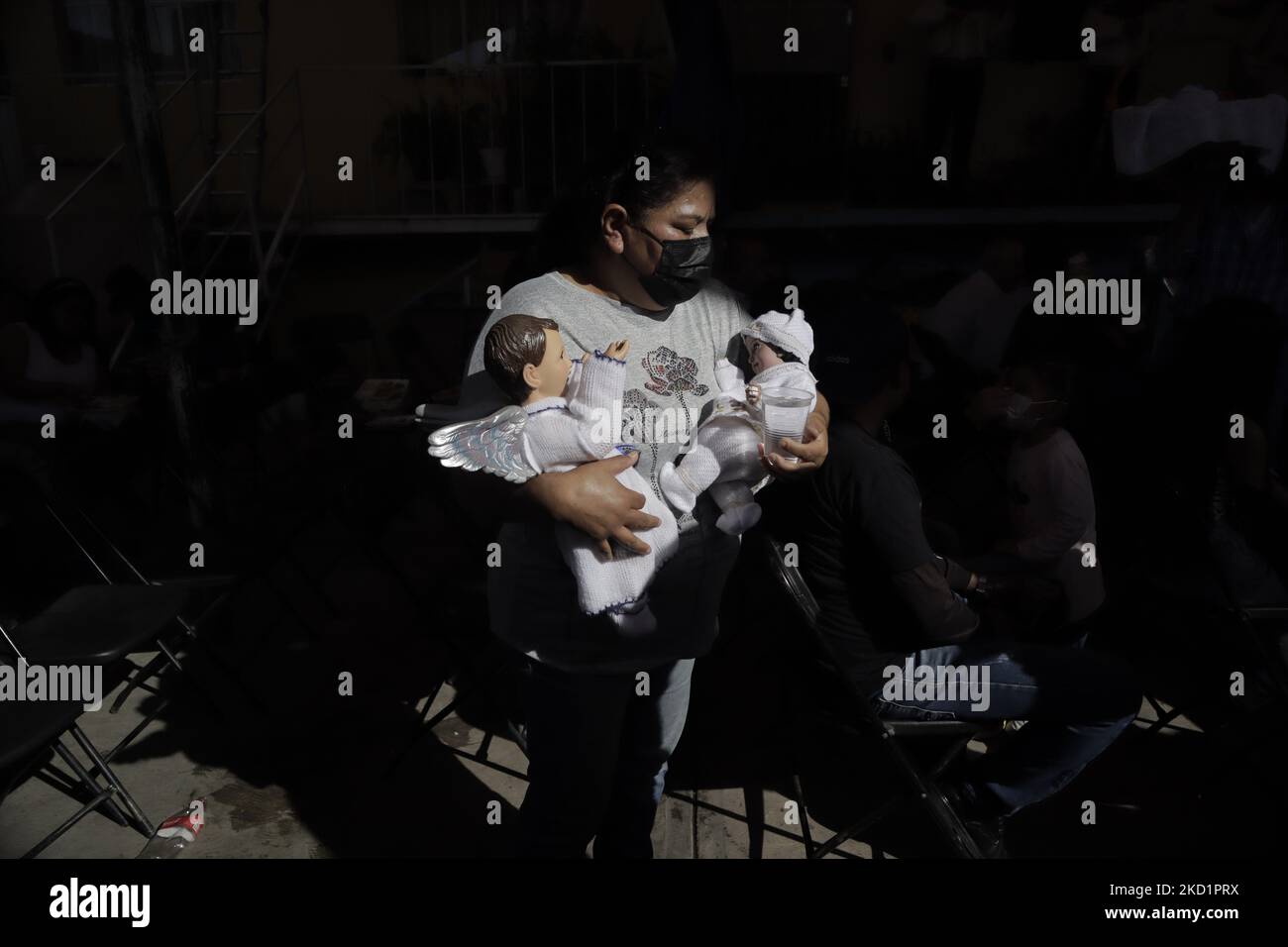 A woman carries two Christ Children into a home in San Francisco ...