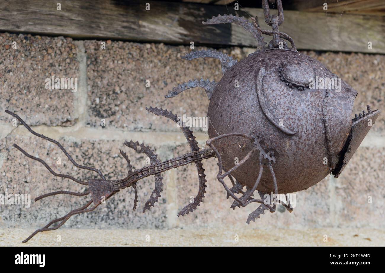 A strange fish sculpture made from discarded metal objects hangs in a ...
