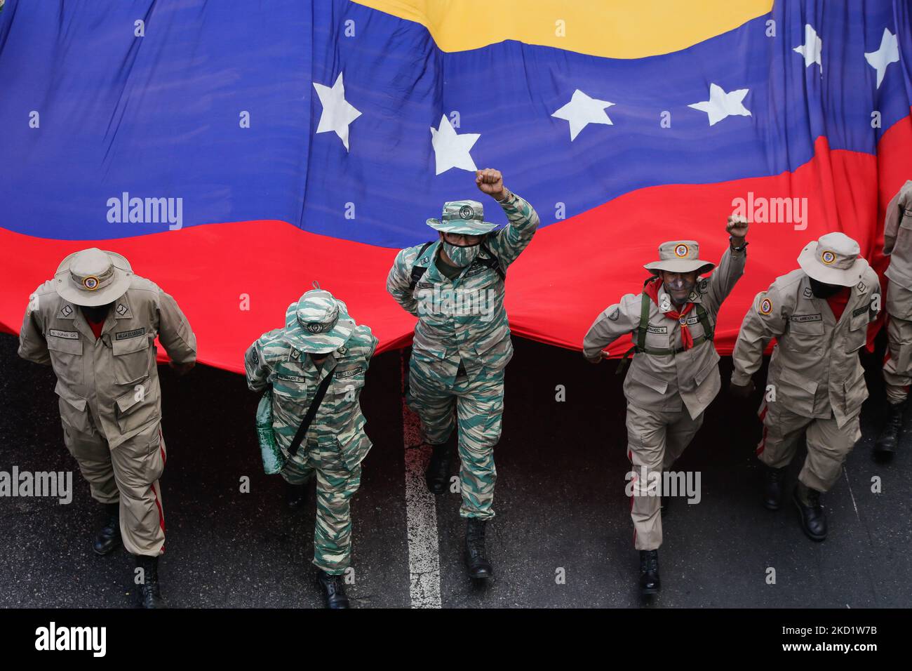 Militiamen hold a Venezuelan flag during a march to commemorate the ...