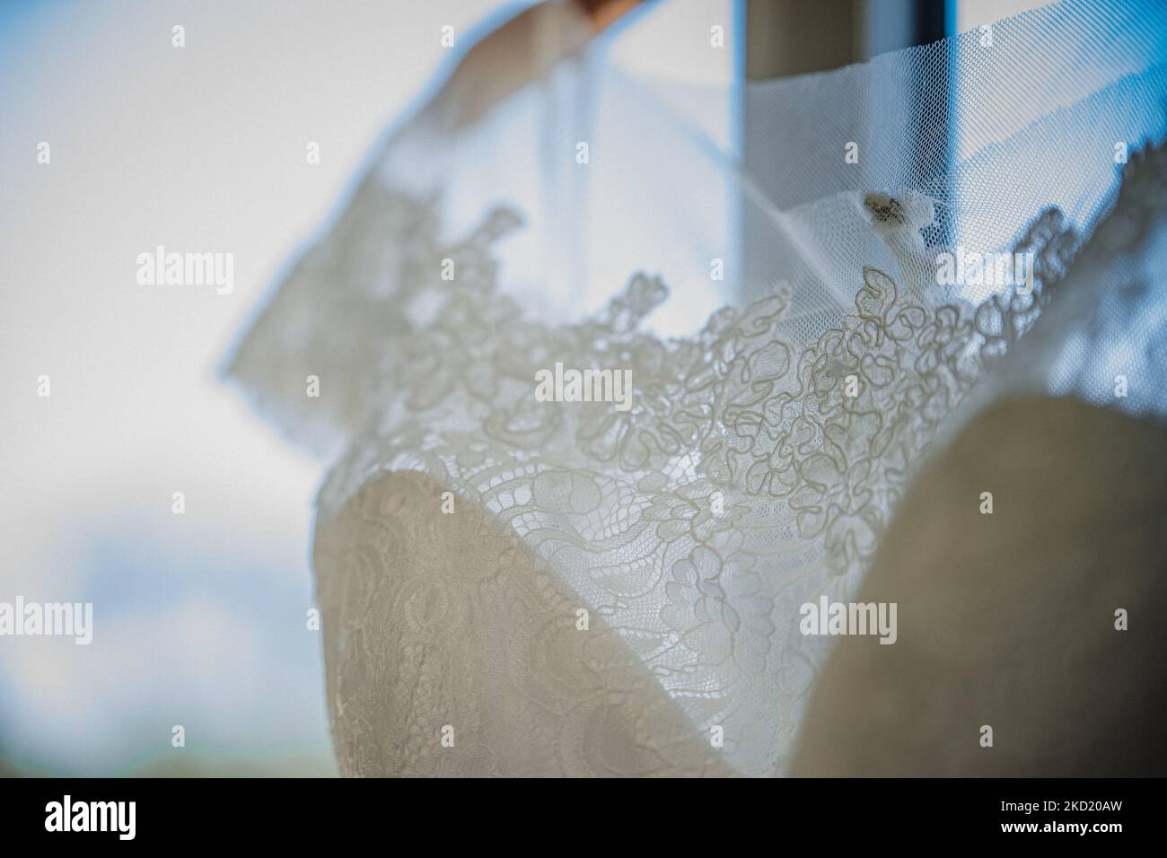A closeup of a lace wedding dress hanging in bride's room Stock Photo ...