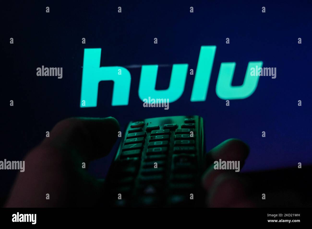 TV remote control is seen with Hulu logo displayed on a screen in this ...