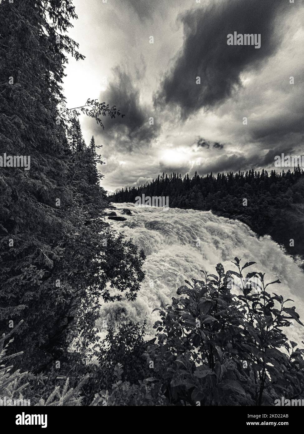 A vertical grayscale shot of a waterfall cascading from the top Stock ...
