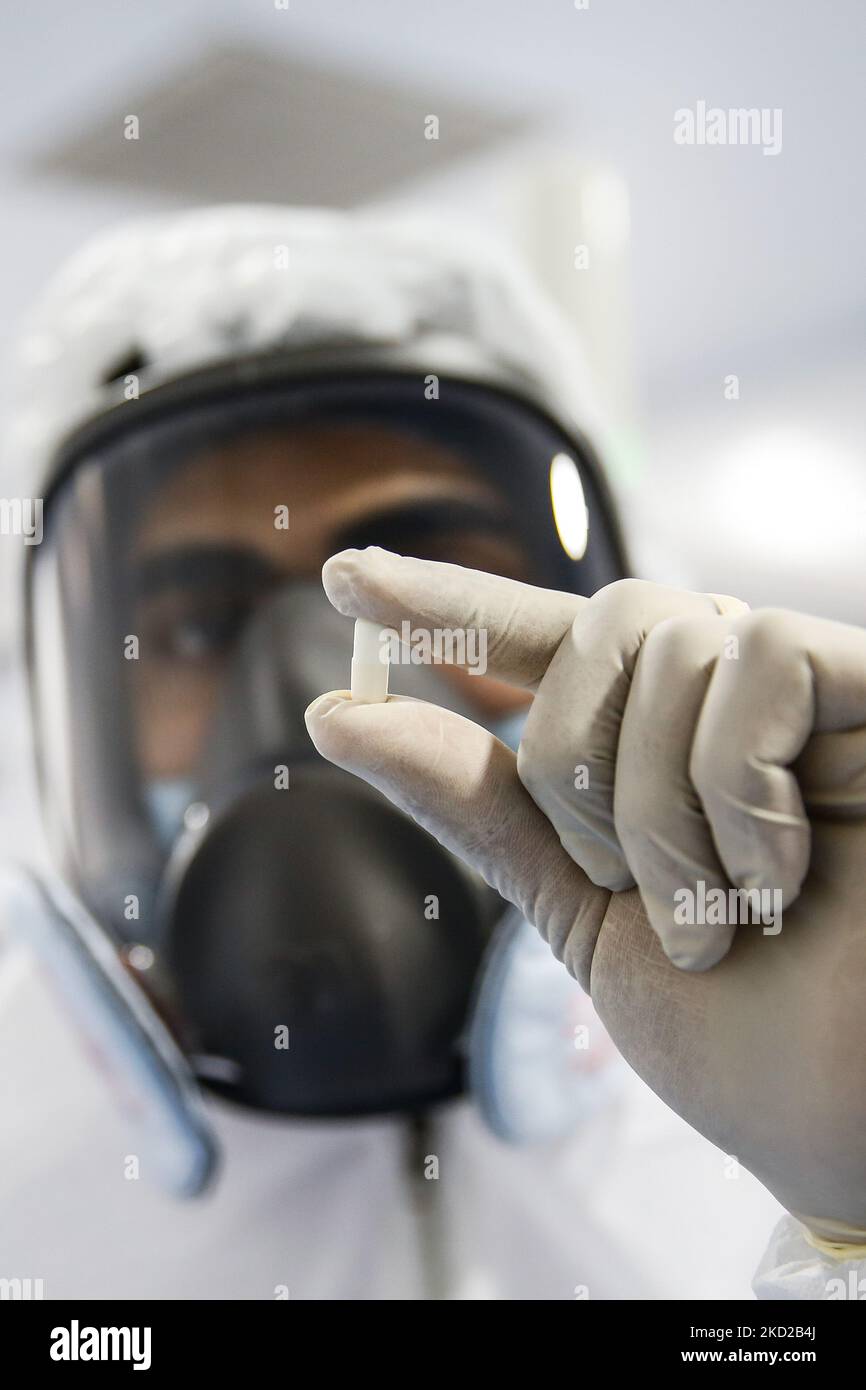 Laboratory technicians wearing full face masks and protective suits ...