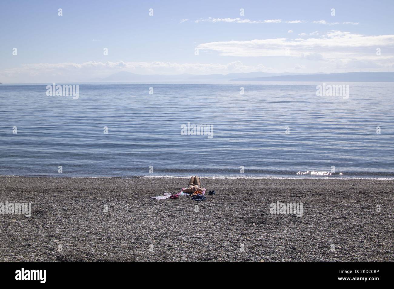 Sunny day and calm sea at Kohili beach, with pebble while a woman ...