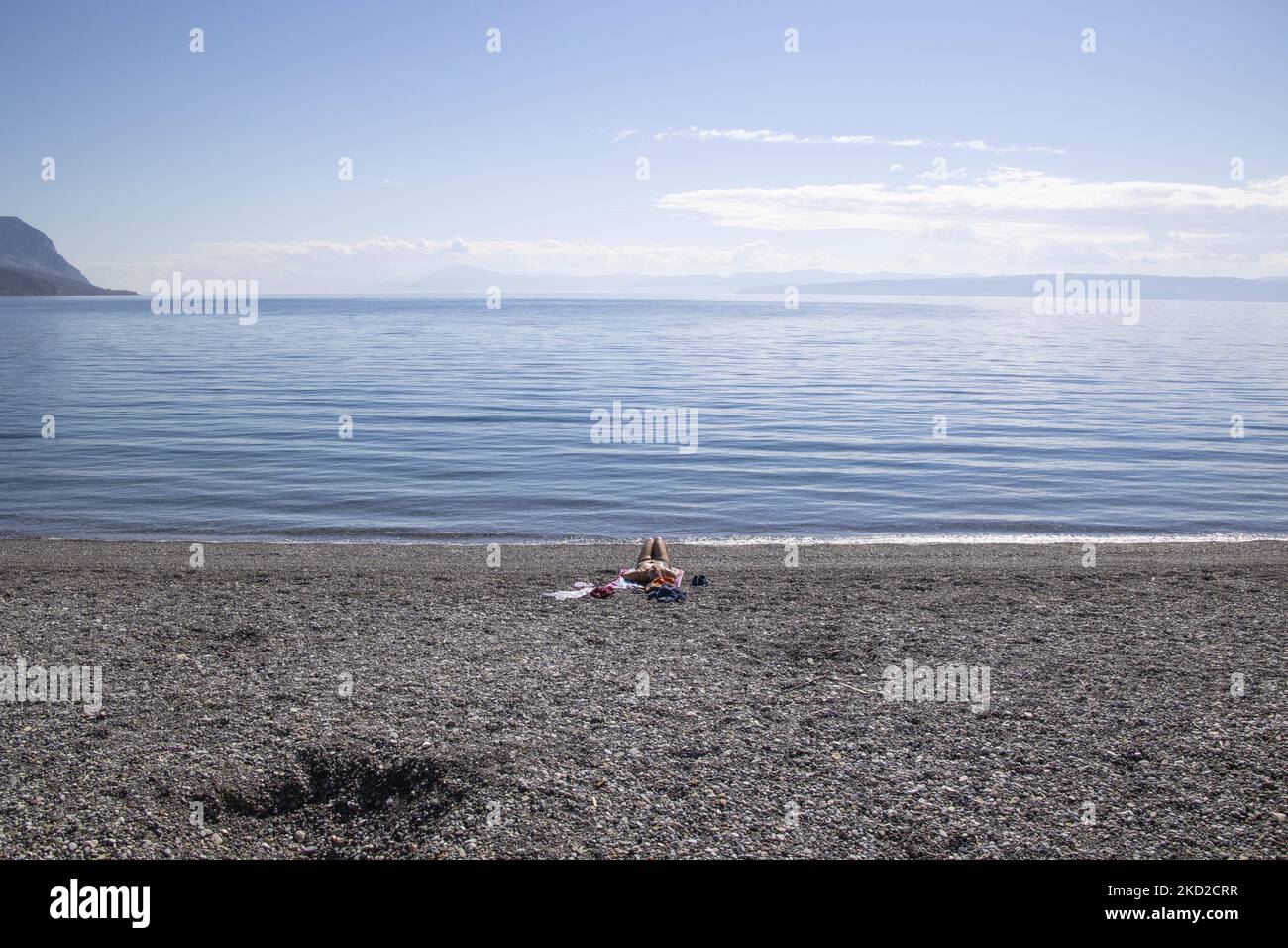 Sunny day and calm sea at Kohili beach, with pebble while a woman ...