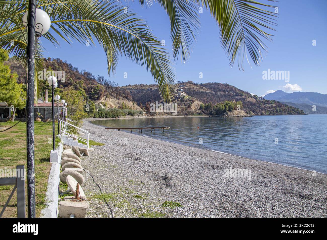 Sunny day and calm sea at Kohili beach, with pebble while a woman ...