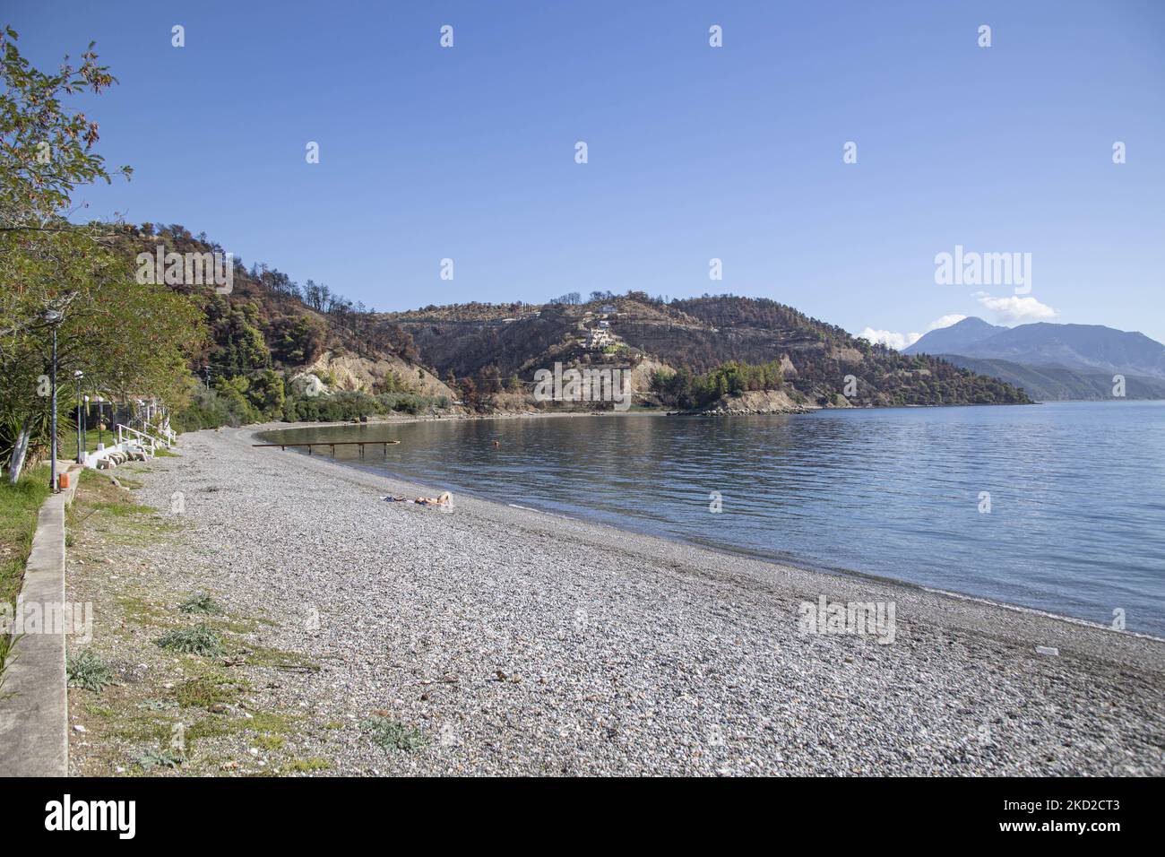 Sunny day and calm sea at Kohili beach, with pebble while a woman ...