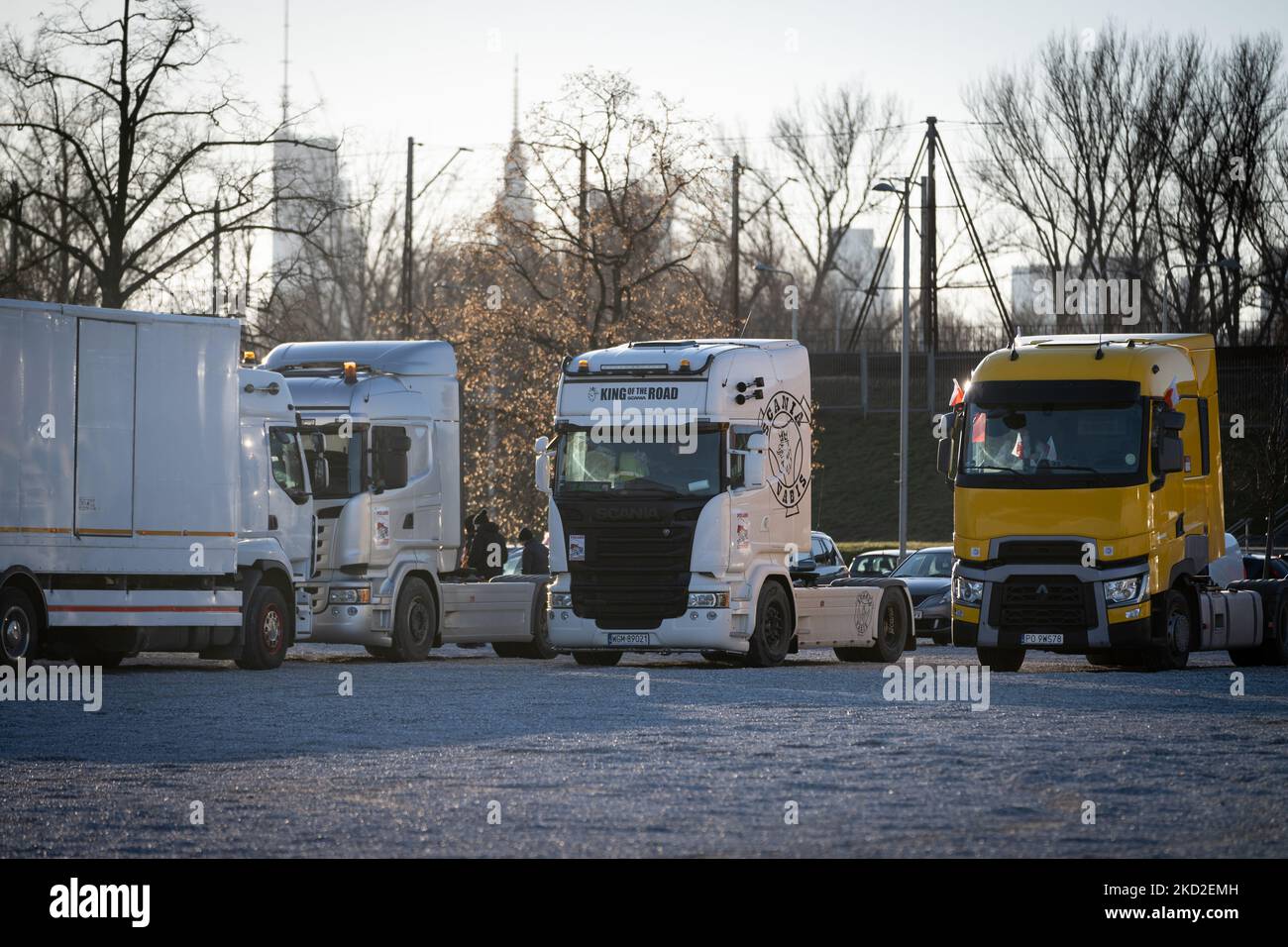 Several trucks and a dozen passenger cars gathered in the parking lot ...