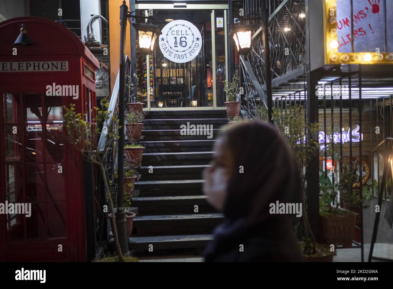 An Iranian woman walks past the CELL-16 fast food jail restaurant which ...