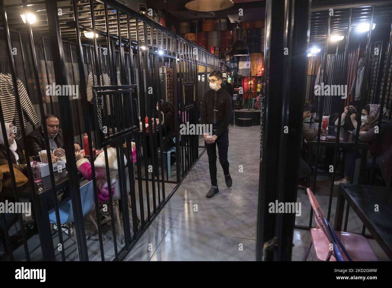 An Iranian waiter walks along a corridor as families eat fast food at ...