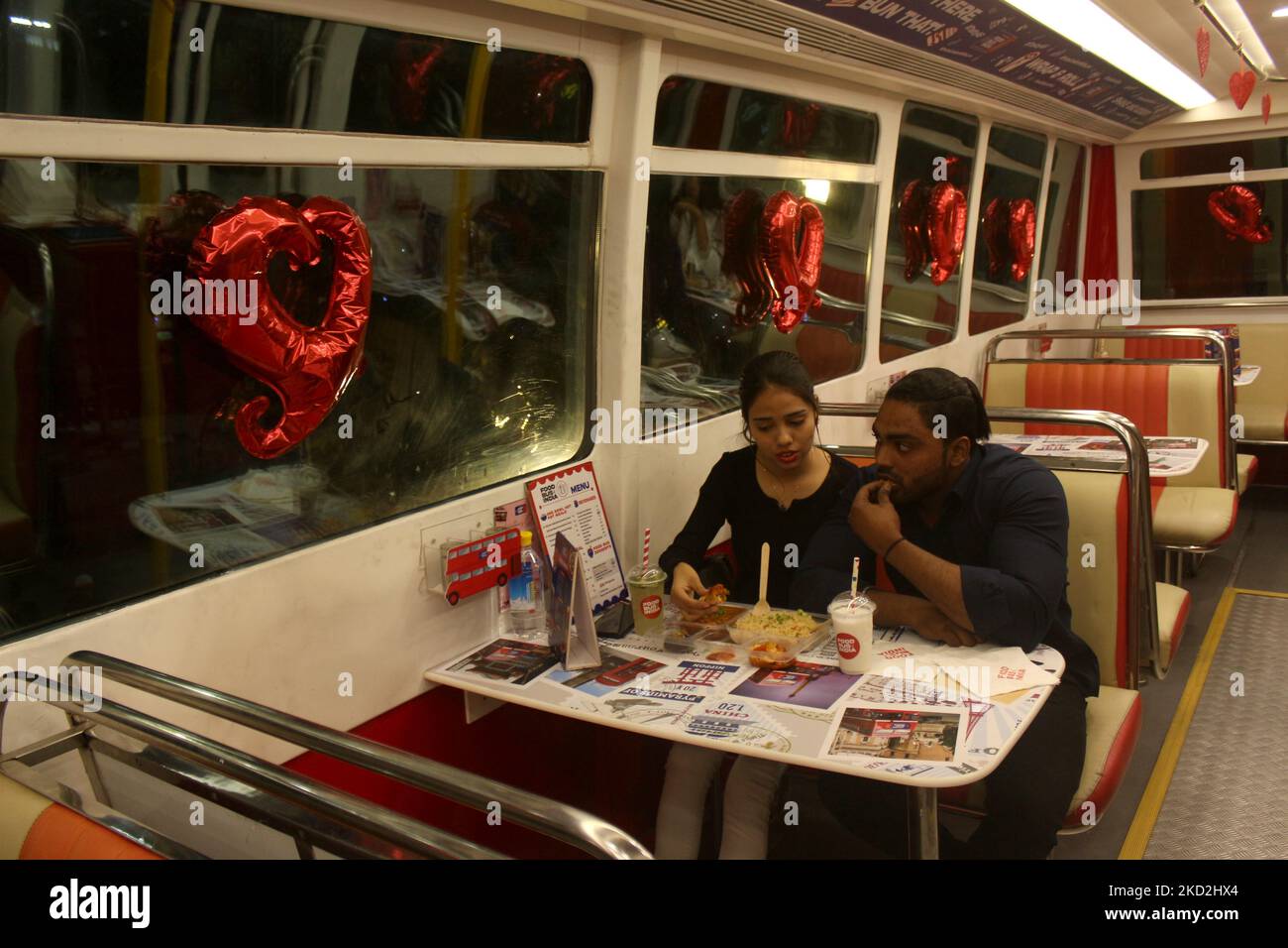 A couple dines inside a double-decker dining bus restaurant, decorated ...