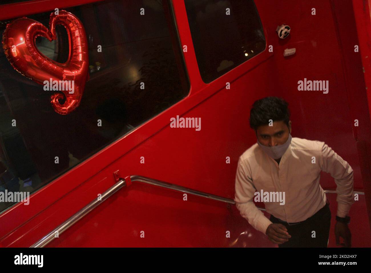 A waiter climbs a stair inside the double-decker dining bus restaurant ...