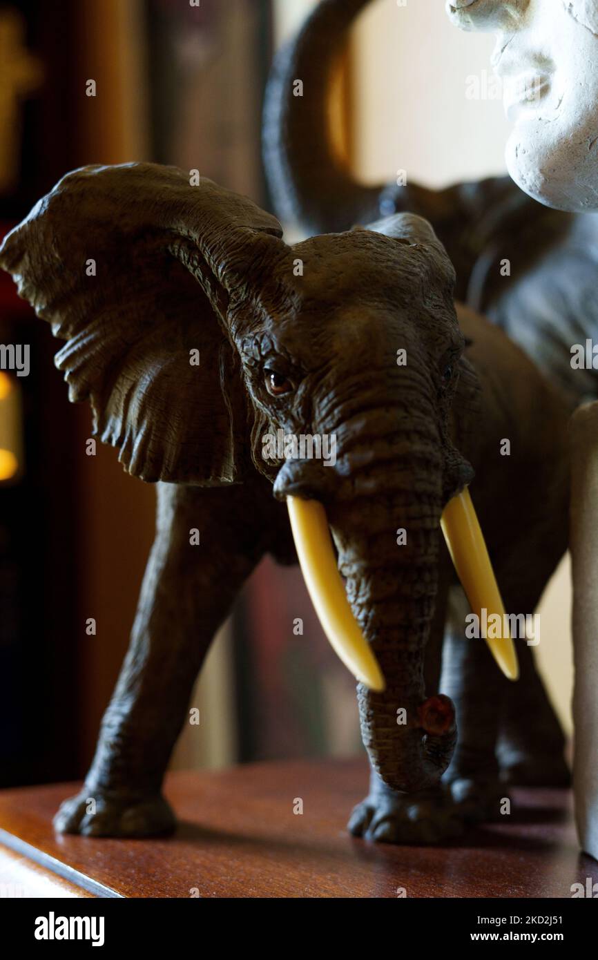 A vertical closeup of a wooden elephant statue on the desk Stock Photo ...