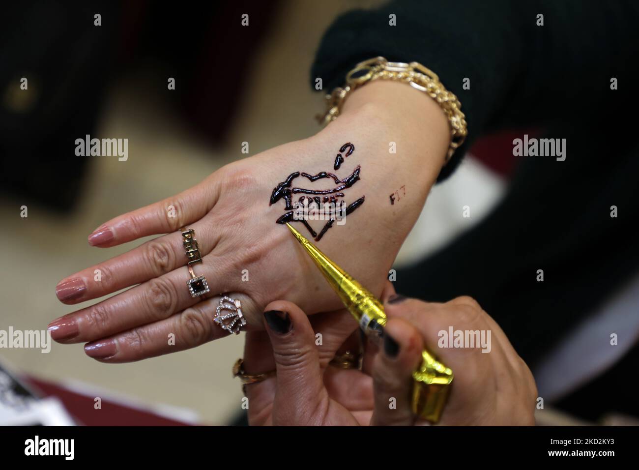 A Palestinian tattoo artist draws a traditional henna tattoo in Gaza ...
