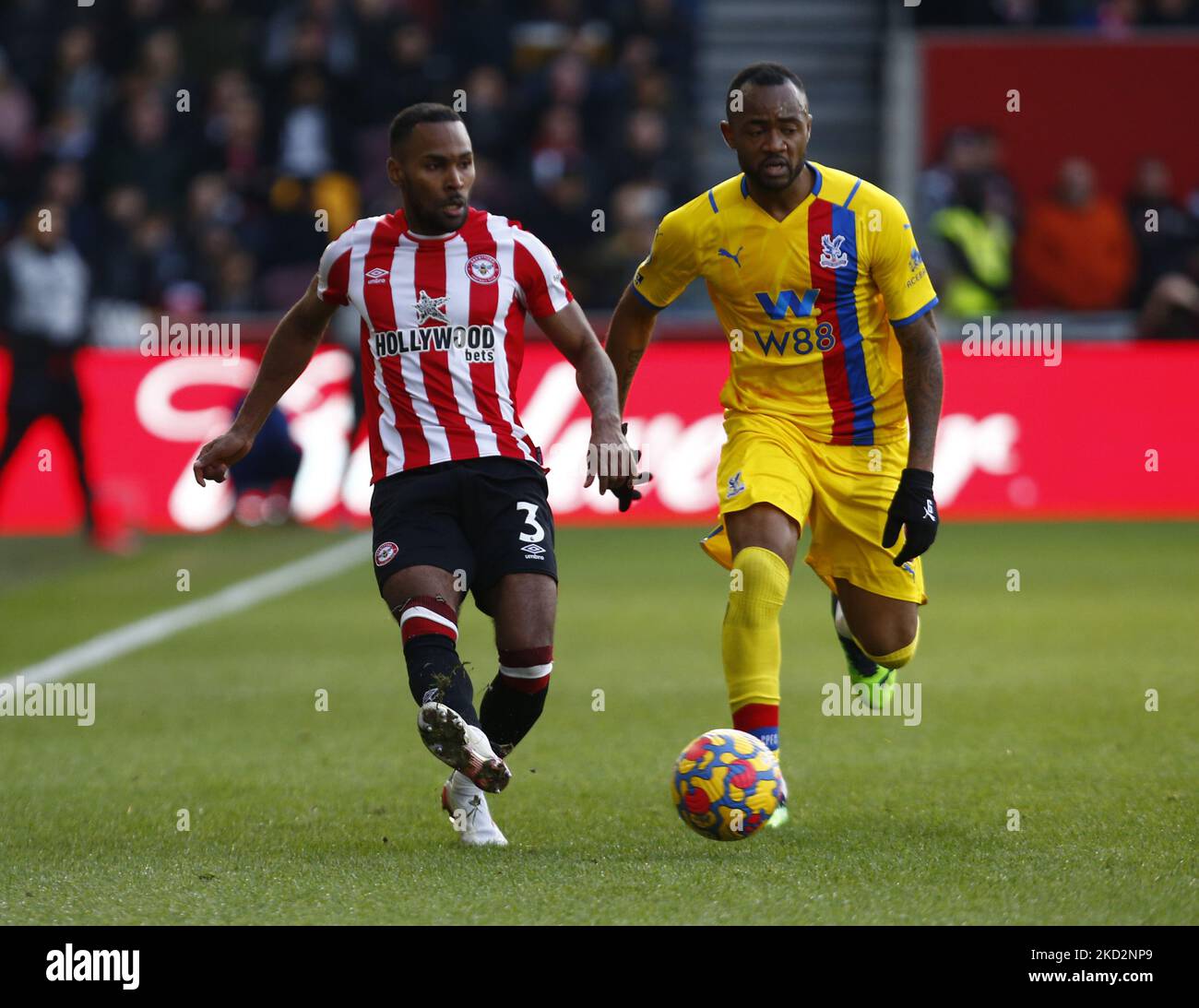L-R Rico Henry of Brentford holds of Crystal Palace's Jordan Ayew ...