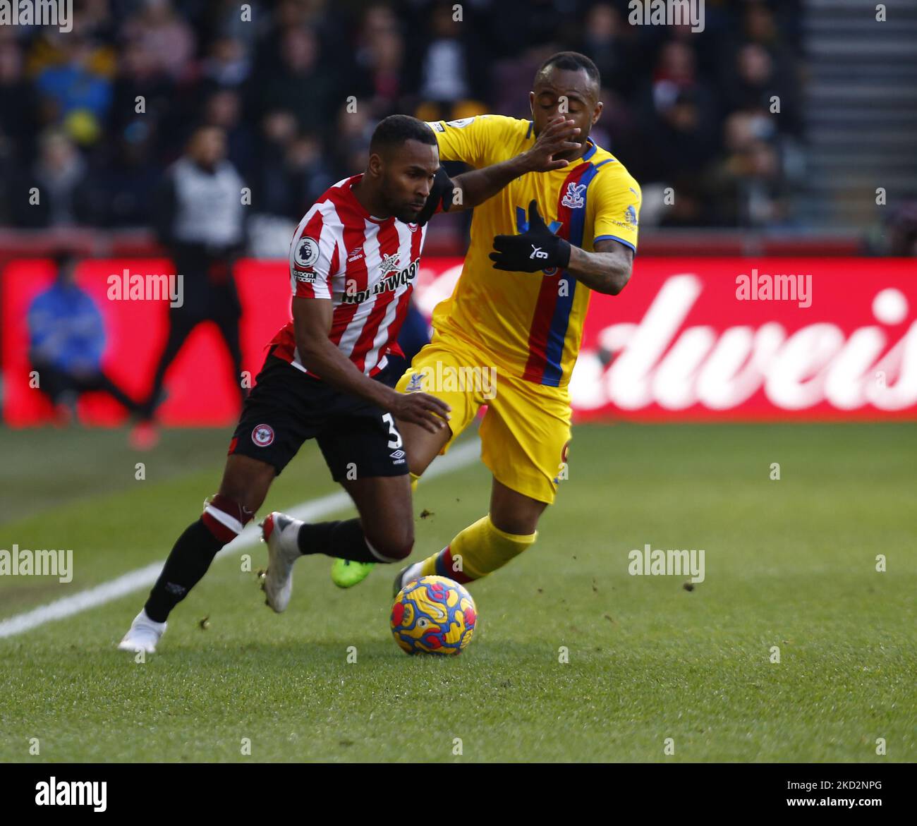 L-R Rico Henry of Brentford holds of Crystal Palace's Jordan Ayew ...