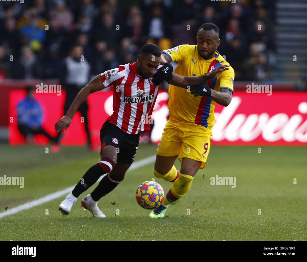 L-R Rico Henry of Brentford holds of Crystal Palace's Jordan Ayew ...