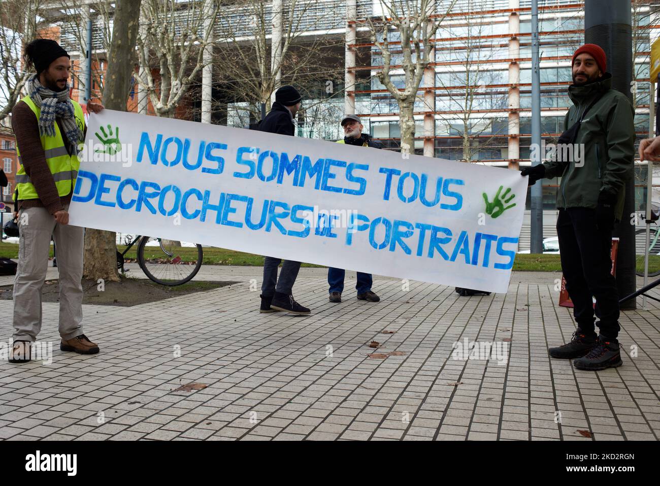 The banner reads 'We'e all takers down of portraits'. Activists from ...