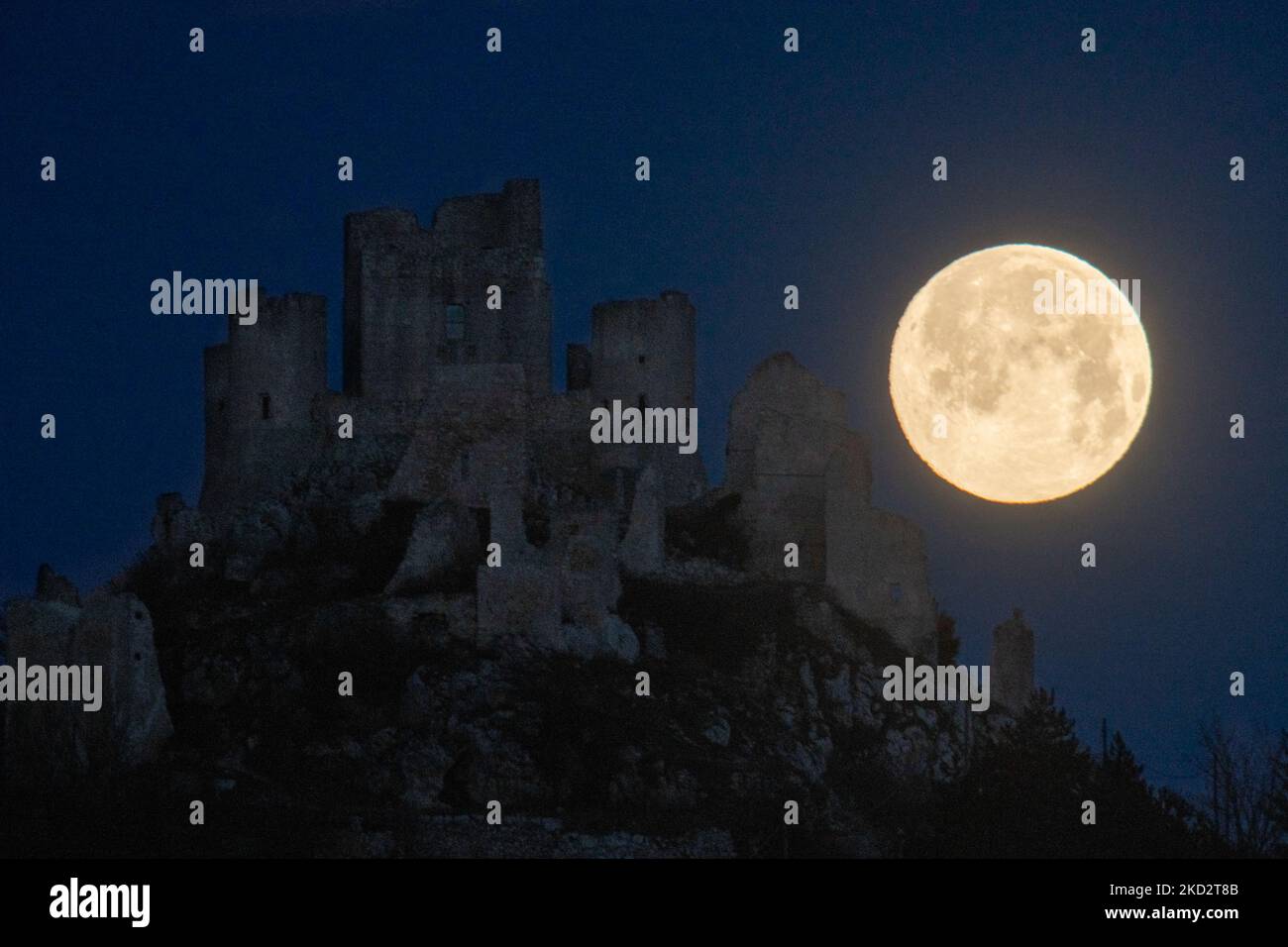 Full moon also known as "Snow Moon" sets behind Rocca Calascio castle ...