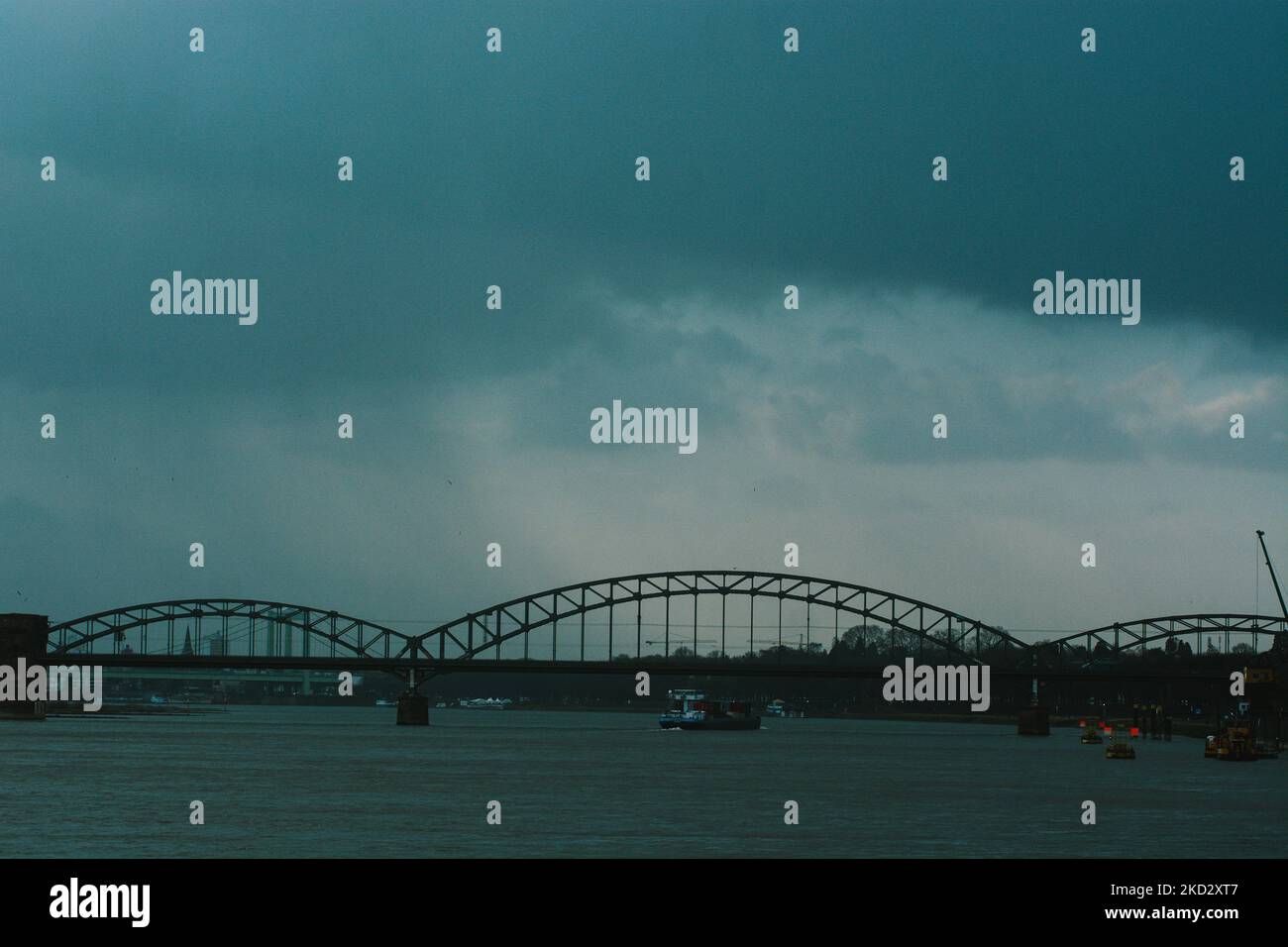 Dark looming grey storm clouds is seen along the rhine river in Cologne ...