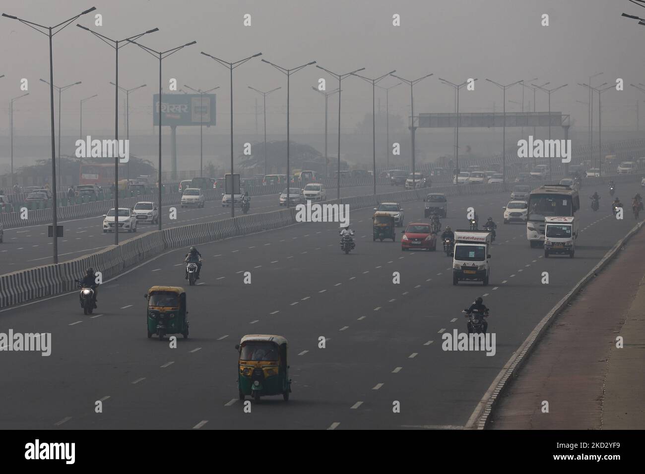People commute along a road amid heavy smog at India Gate in New Delhi ...
