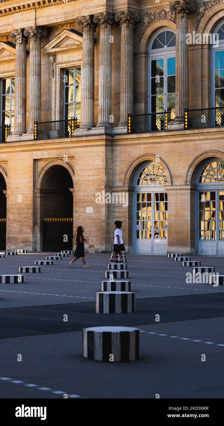 A vertical shot of the children playing on the Colonnes de Buren in ...