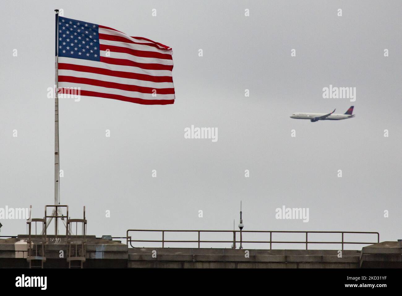 The US flag waving on the tower of the Brooklyn Bridge in New York City ...