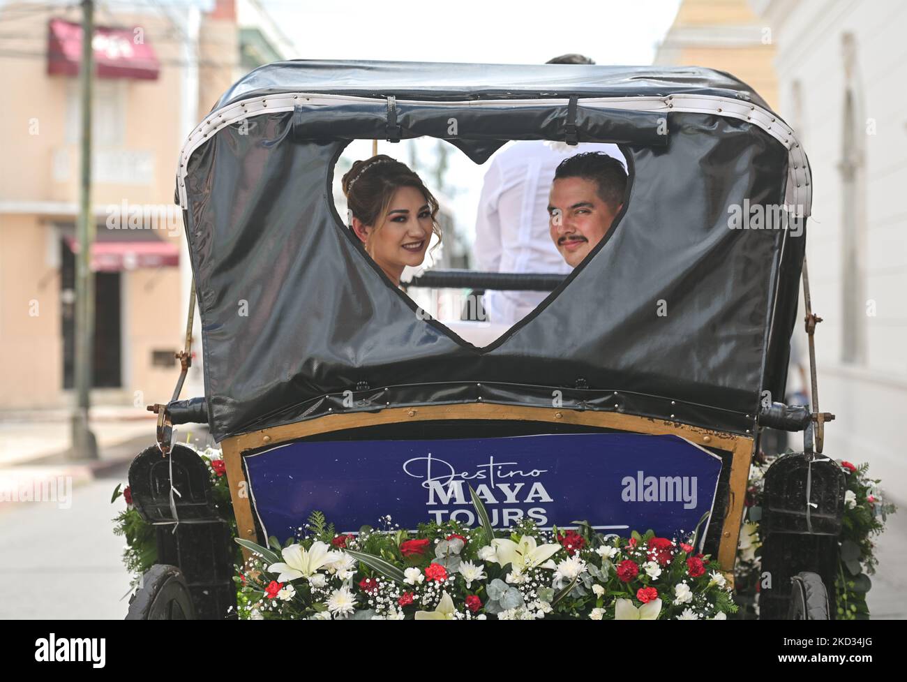 A newly married couple in a carriage driving through downtown Merida ...