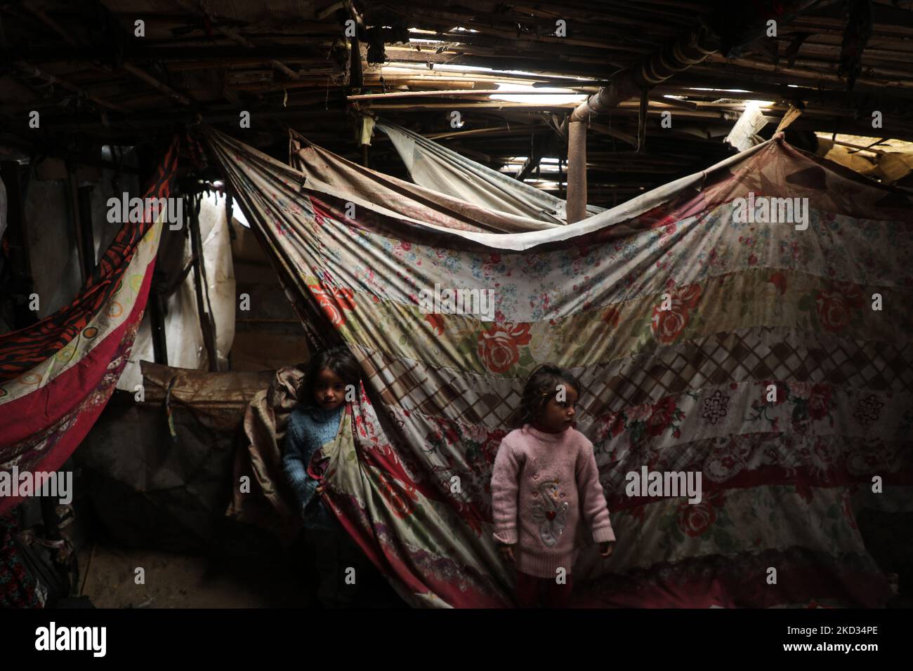 A Palestinian woman sits with a tray of bread inside her home, in Beit ...