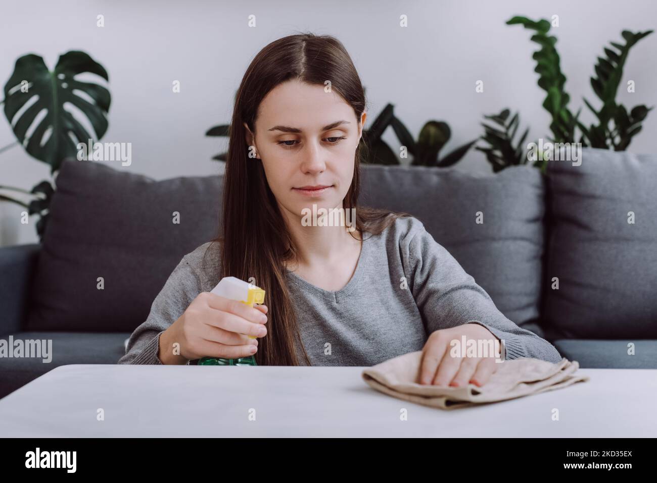 Close up of young caucasian woman tidy housewife cleaning white wooden ...