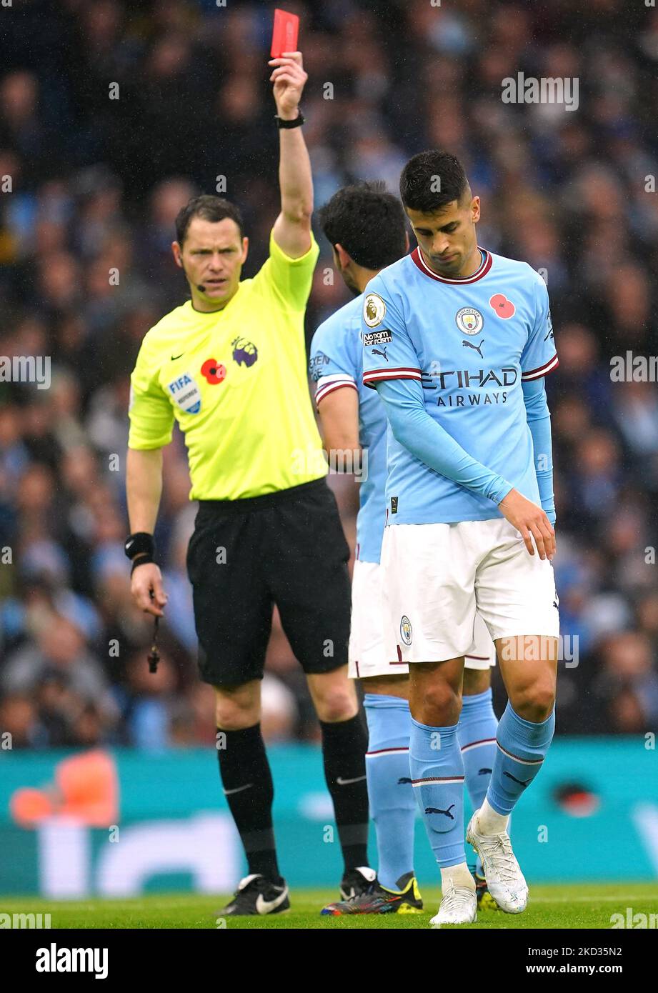 Referee Darren England (left) shows a red card to Manchester City's ...