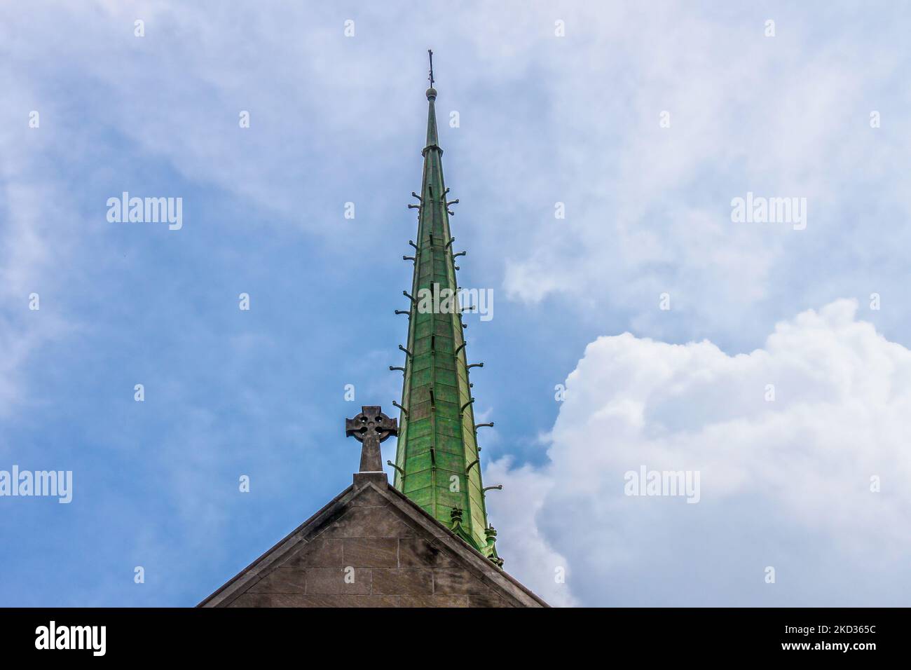 Copper art deco church spire and Celtic cross on top of church against ...