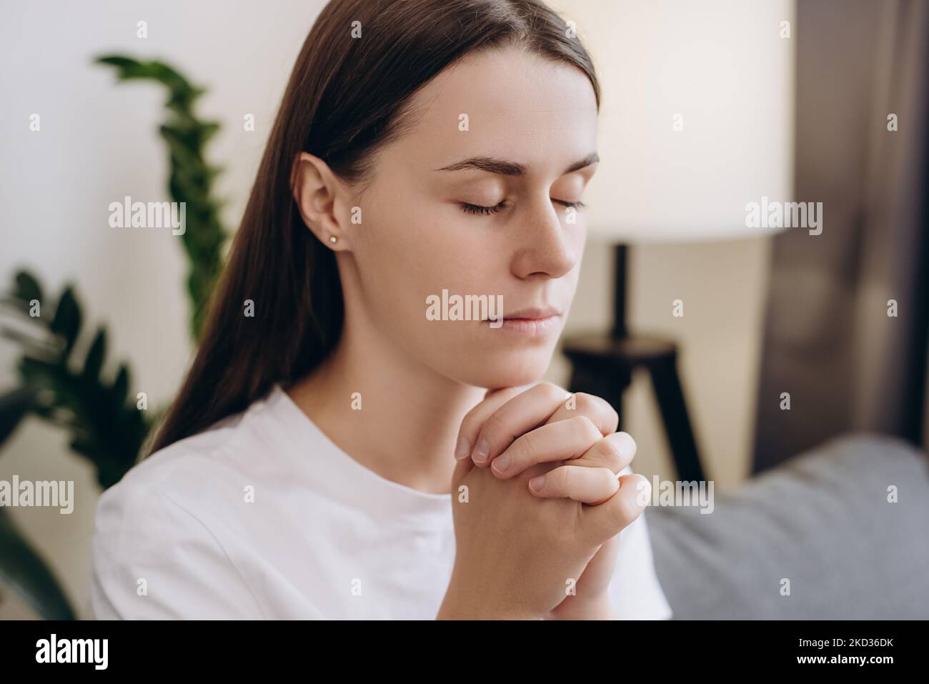 Cute girl praying sincerely with folded arms and making wish, asking ...