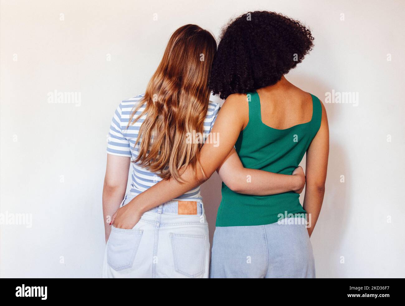 Strong female friendship. Rear view two teen girls best friends holding ...