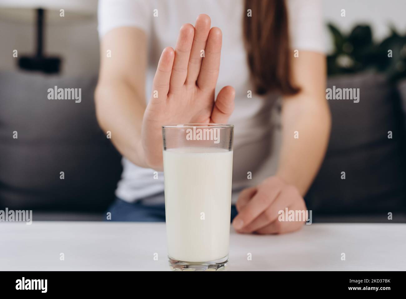 Lactose intolerance concept. Close up of young woman pushing glass of ...