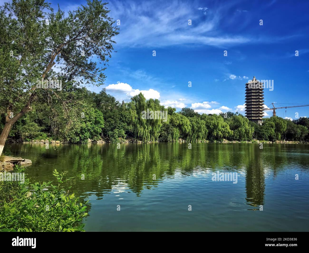 The beautiful lake of Weiming with trees reflected in the waters and ...