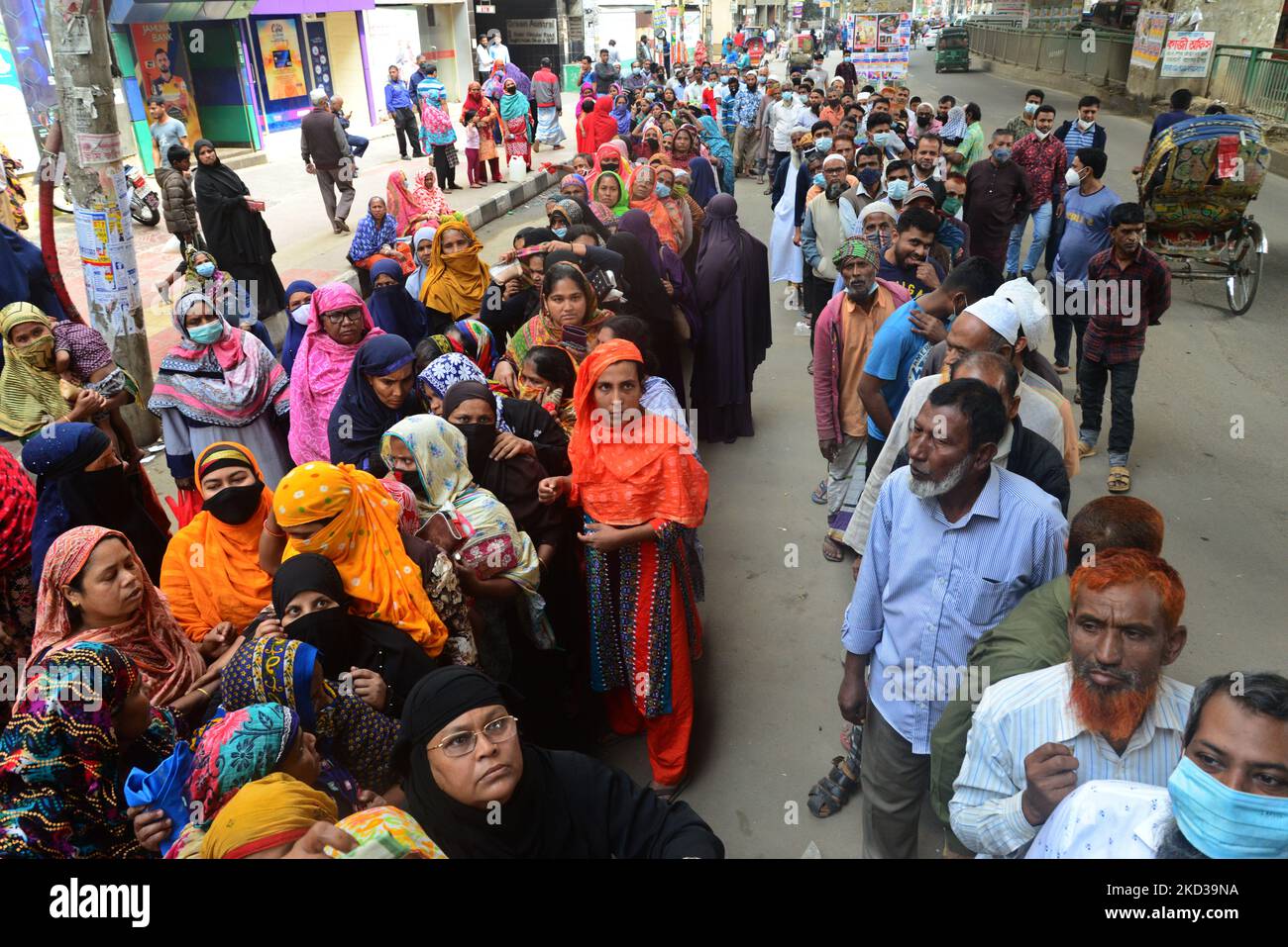 People stand in line to buy government-subsidized goods from a TCB ...