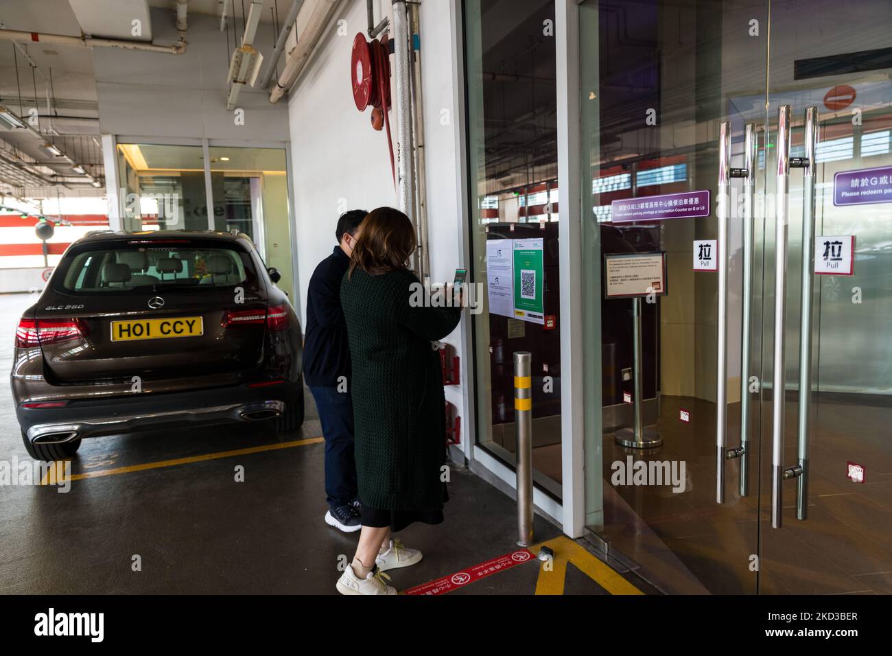 Office workers scan the Leave Home Safe QR code before entering a the ...