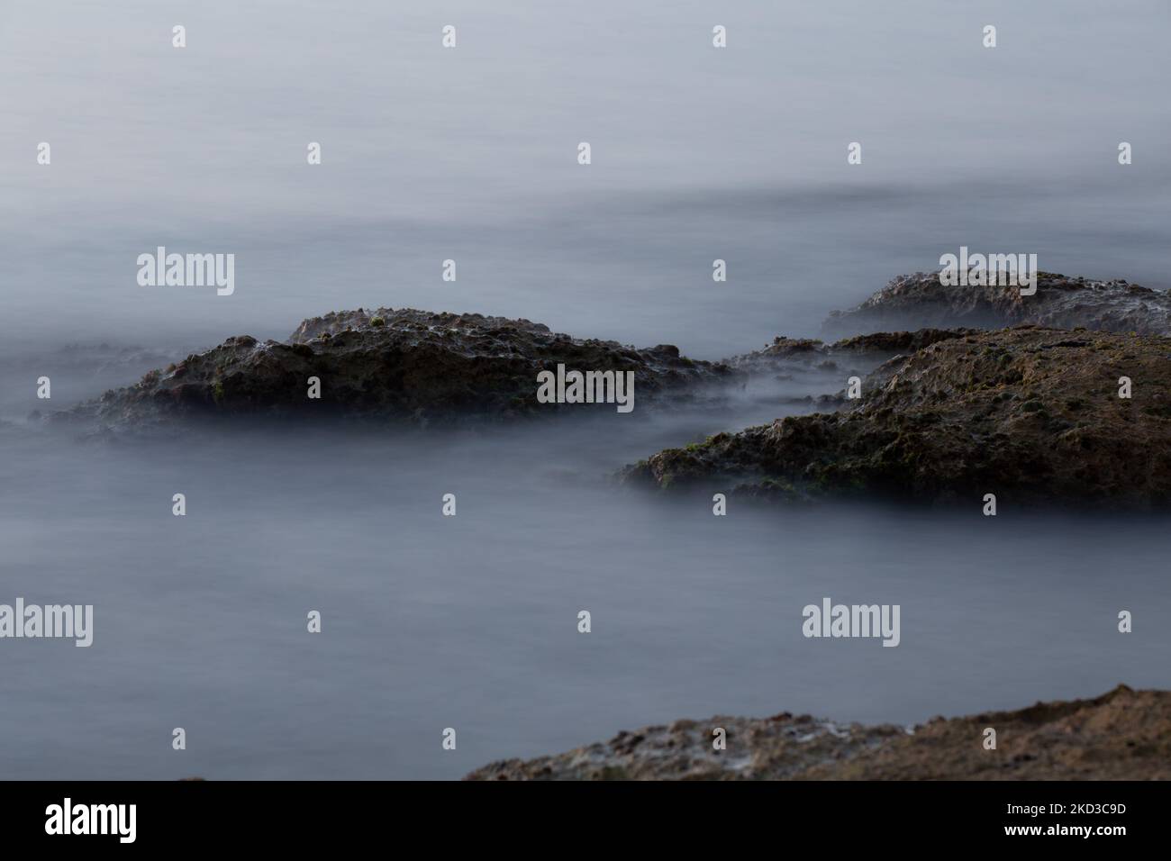 An aerial view of a floating layer of clouds over rocky mountains and cliffs Stock Photo - Alamy