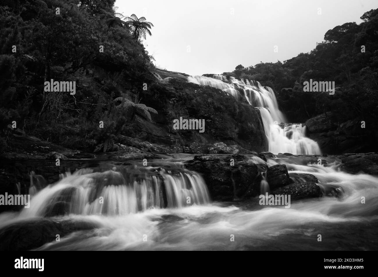 A grayscale shot of Baker's waterfall in high contrast with a cliff and ...