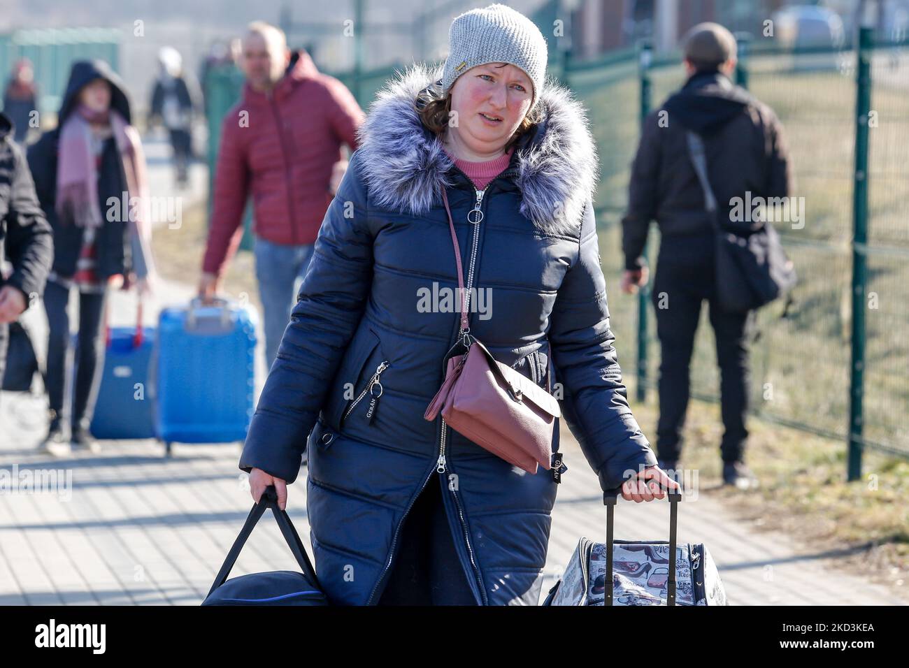 An Ukrainian arrives at Polish border crossing as tens of thousands ...