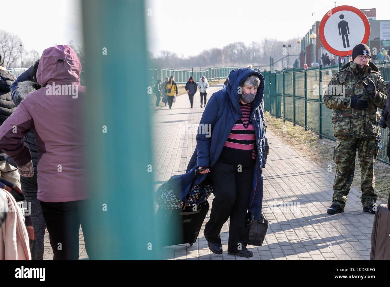 An Ukrainian arrives at Polish border crossing as tens of thousands ...