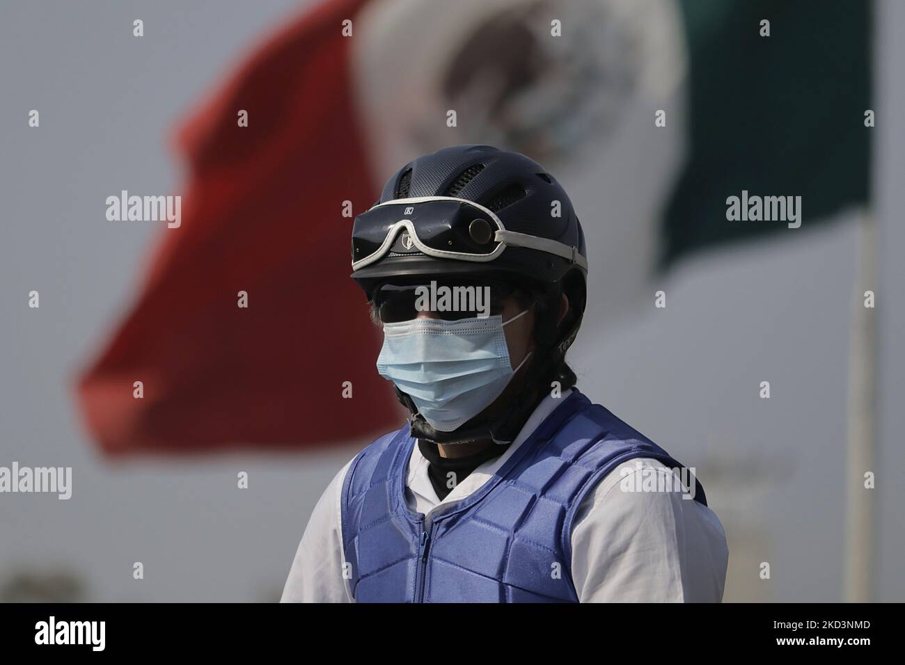 A jockey in front of a monumental flag at the Hipódromo de Las Américas ...