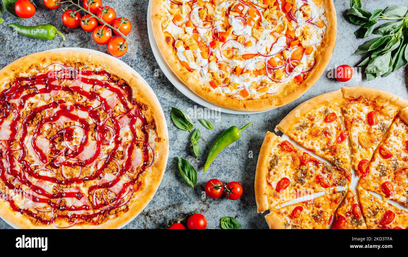 A top view of different types of freshly baked homemade pizzas on a ...