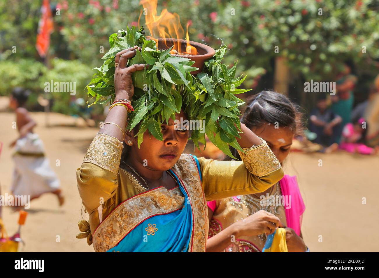 Tamil Hindu woman carries a clay pot with flaming camphor on her during ...