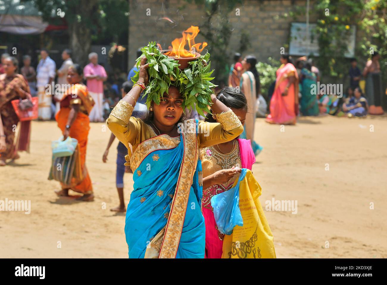 Tamil Hindu woman carries a clay pot with flaming camphor on her during ...