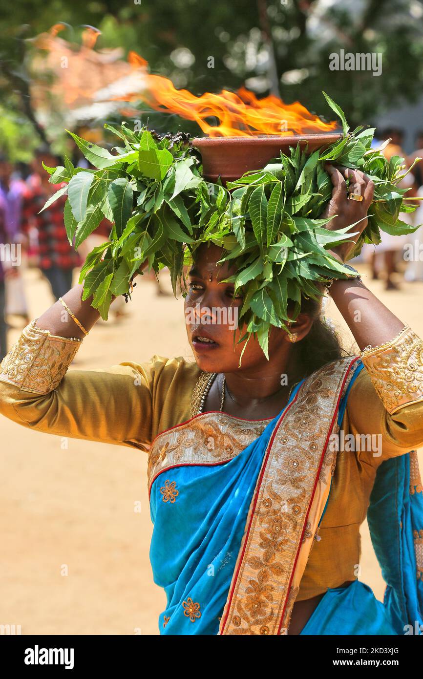 Tamil Hindu woman carries a clay pot with flaming camphor on her during ...