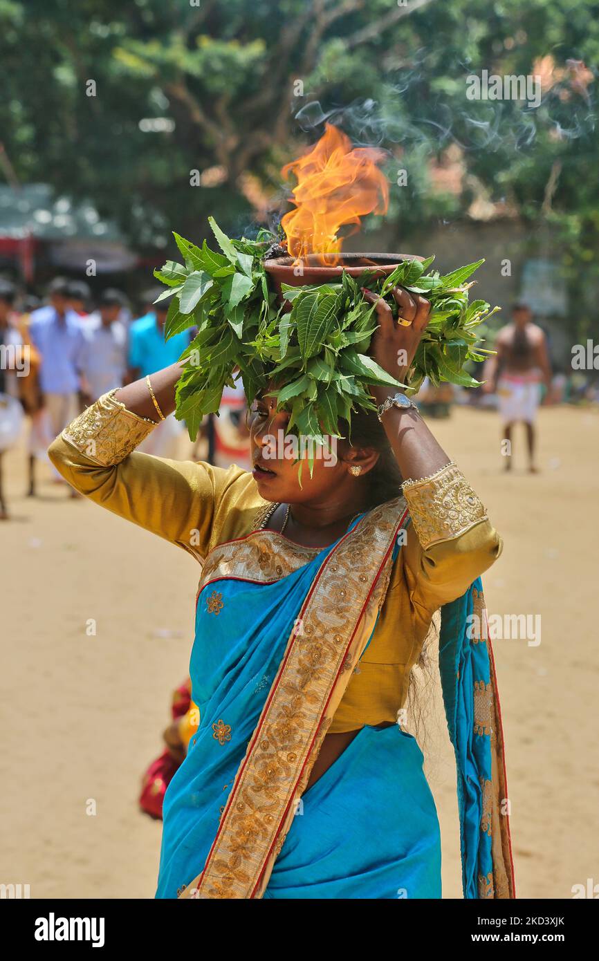 Tamil Hindu woman carries a clay pot with flaming camphor on her during ...